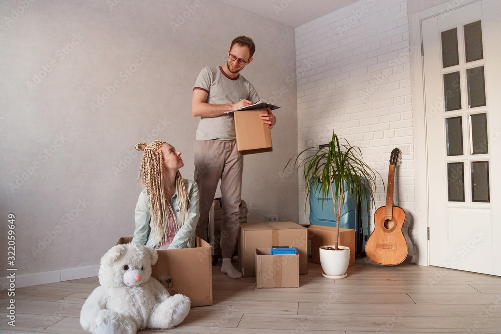 Young family make inventory of things during the move. a man with a ...