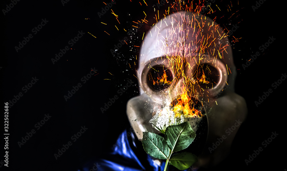 Man in the gas mask holding a burning flower. Radiation influence ...