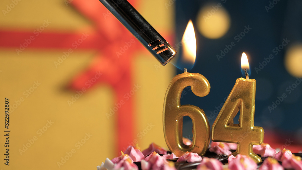 Photo Stock Birthday cake number 64 golden candles burning by lighter ...