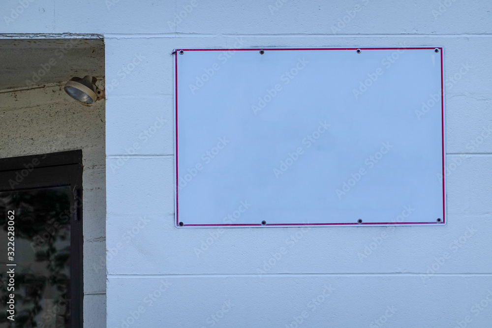 Blank white sign on a white cinder block wall の Stock フォト | Adobe Stock