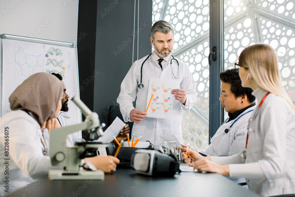 Handsome middle aged man doctor explaining information for his students ...