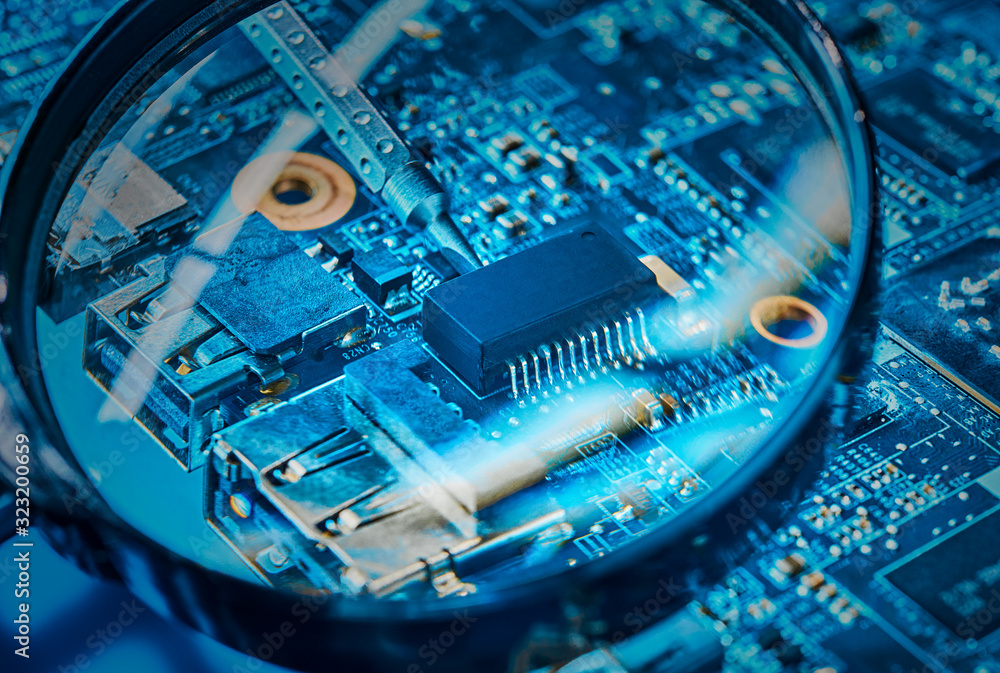 Chip on the computer's motherboard close-up through a magnifying glass ...