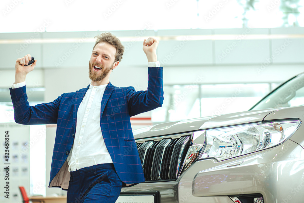 excited happy caucasian man after getting new car in dealership, joyful ...