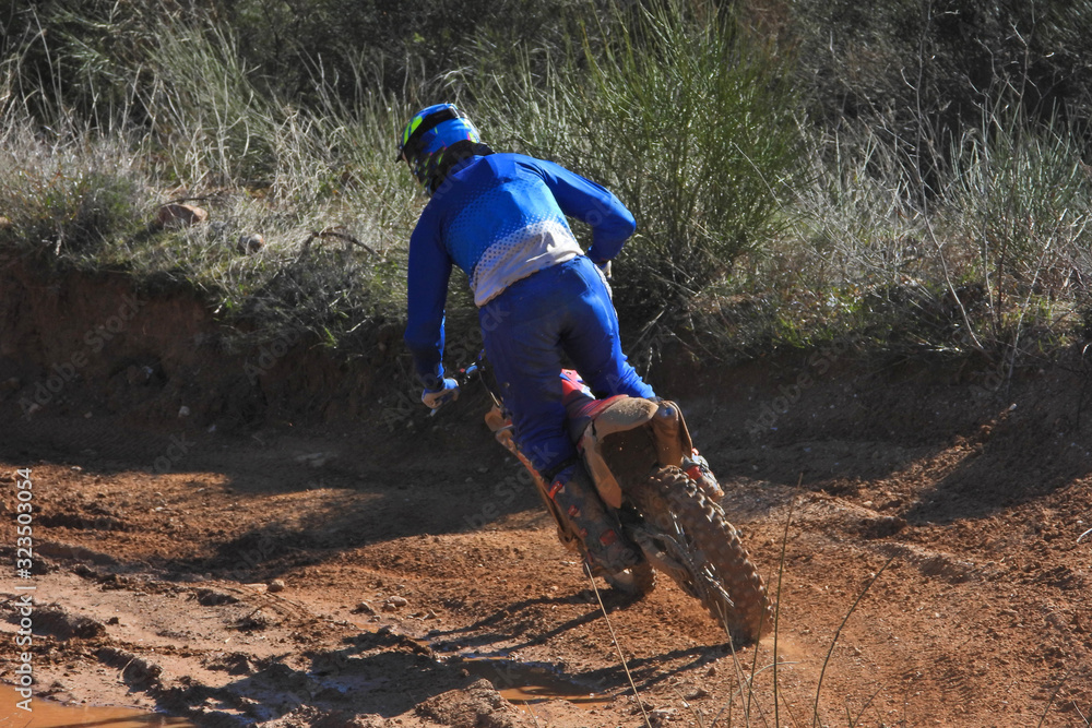 Zoom photo of mud track enduro motocross rider performing freestyle ...