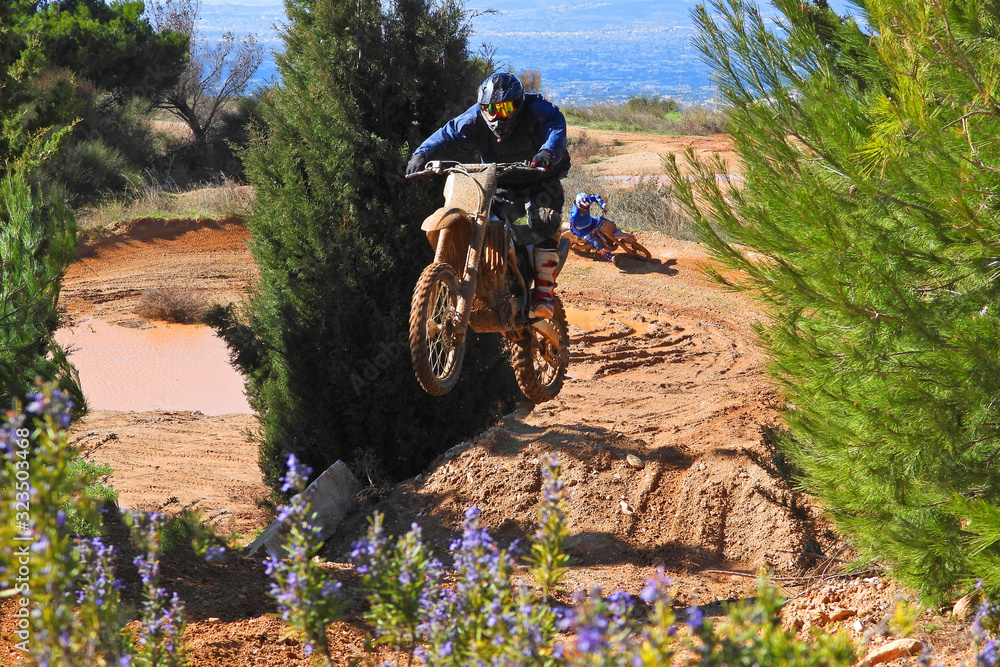 Zoom photo of mud track enduro motocross rider performing freestyle ...