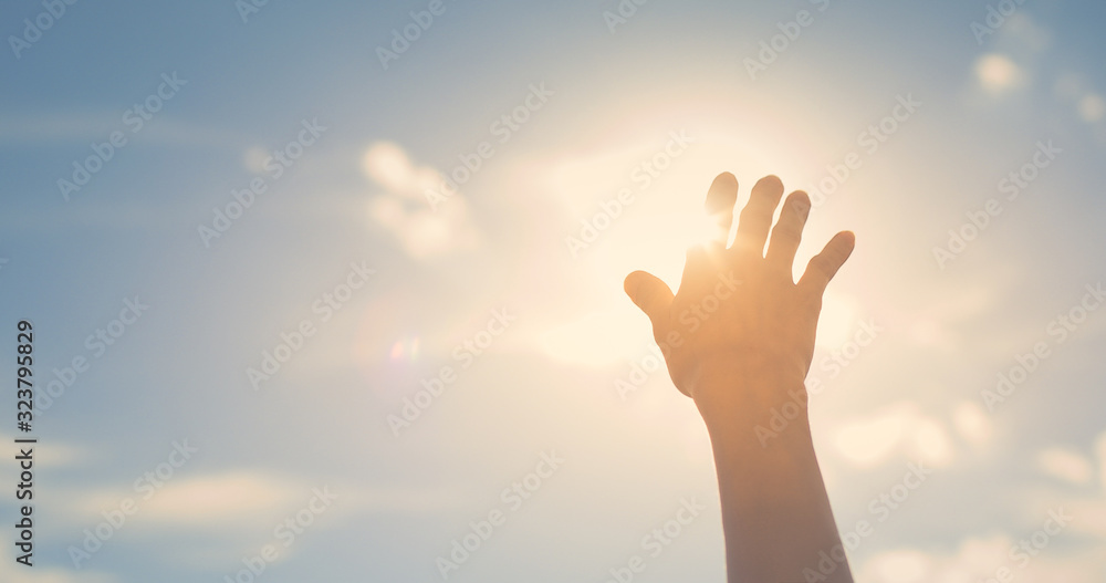 Hand reaching up touching the sun sunset sky with rays of light ...