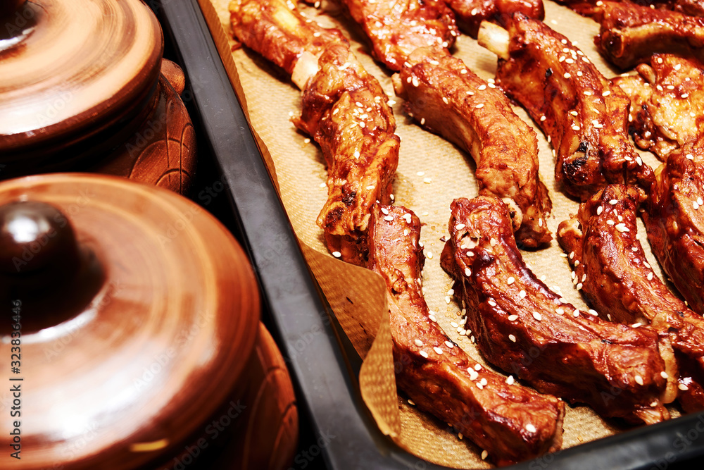 Ceramic stewing pots and barbecue ribs with sesame seeds on papyrus ...