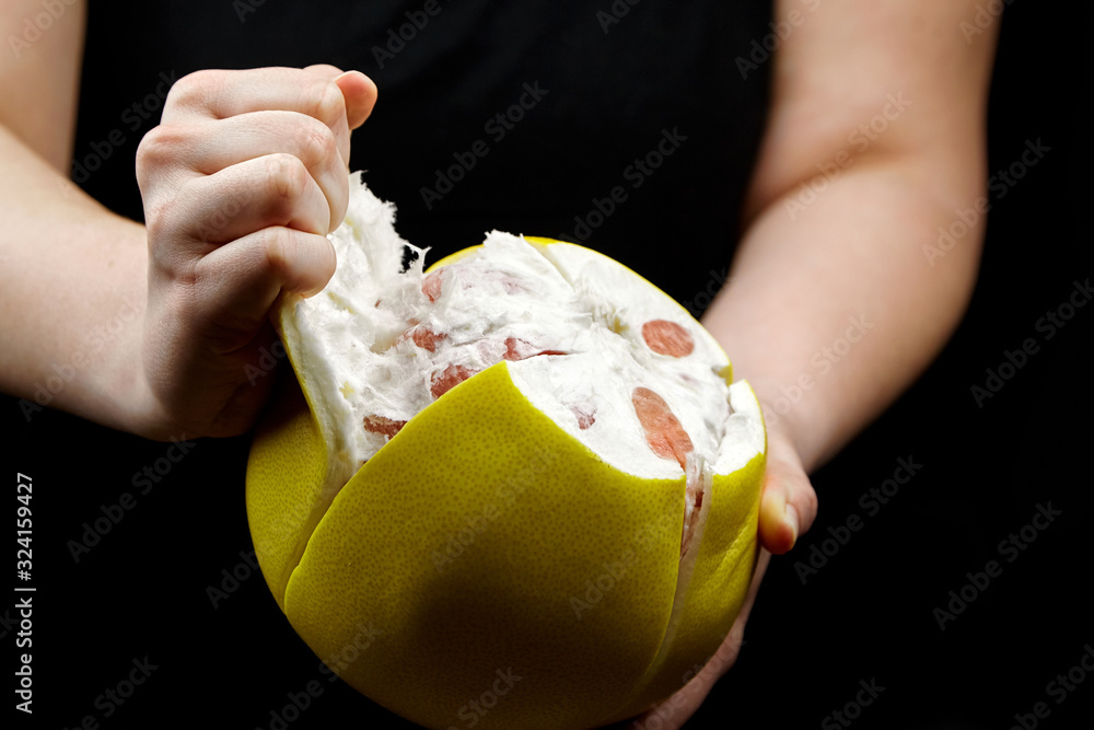 Pomelo citrus fruit with sweet red flesh and yellow thick rind on black ...