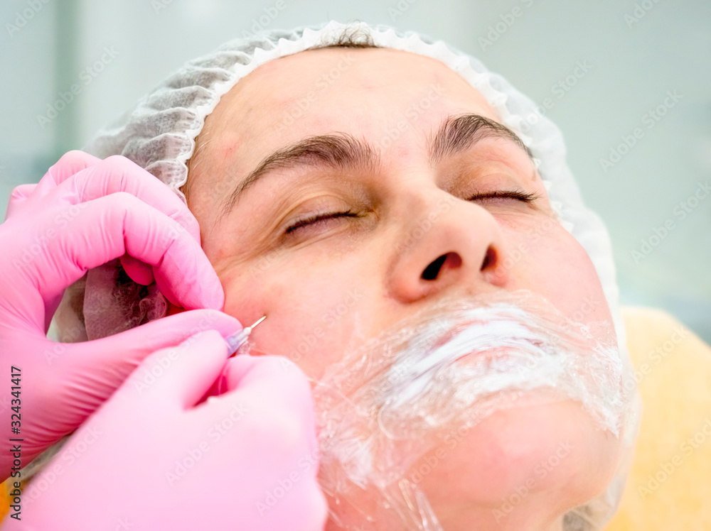 contour plastic. A cosmetologist injects a botulinum toxin to tighten ...