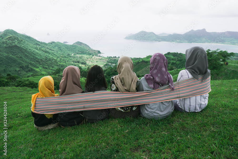Six girls sitting on the top of white thatch hill. A view of the ...
