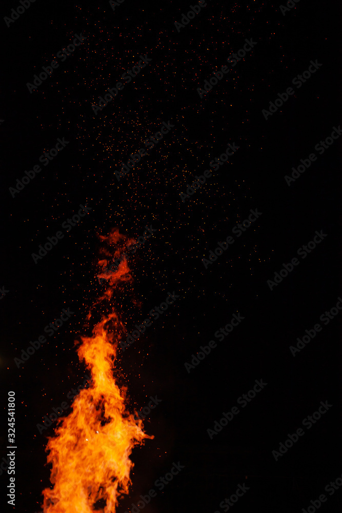 Fire flames on a dark background with lots of fiery sparks from a ...