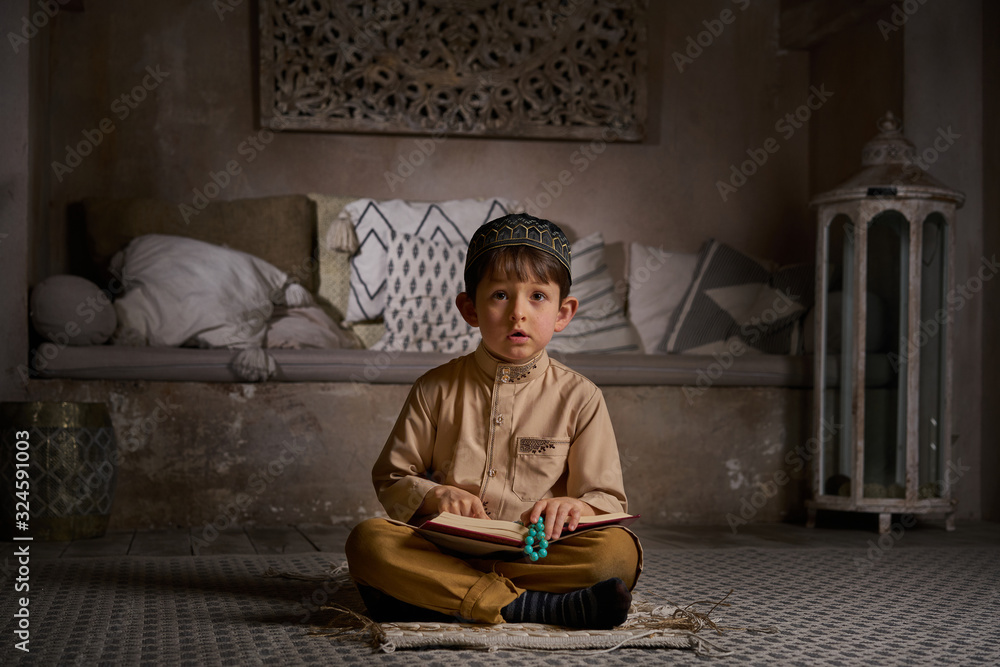 Foto de Stock Boy in arabic clothes with rosary beads reading holy ...