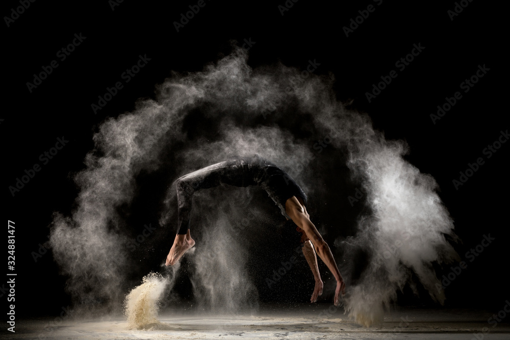 Male gymnast jumping in dust cloud profile view Stock Photo | Adobe Stock