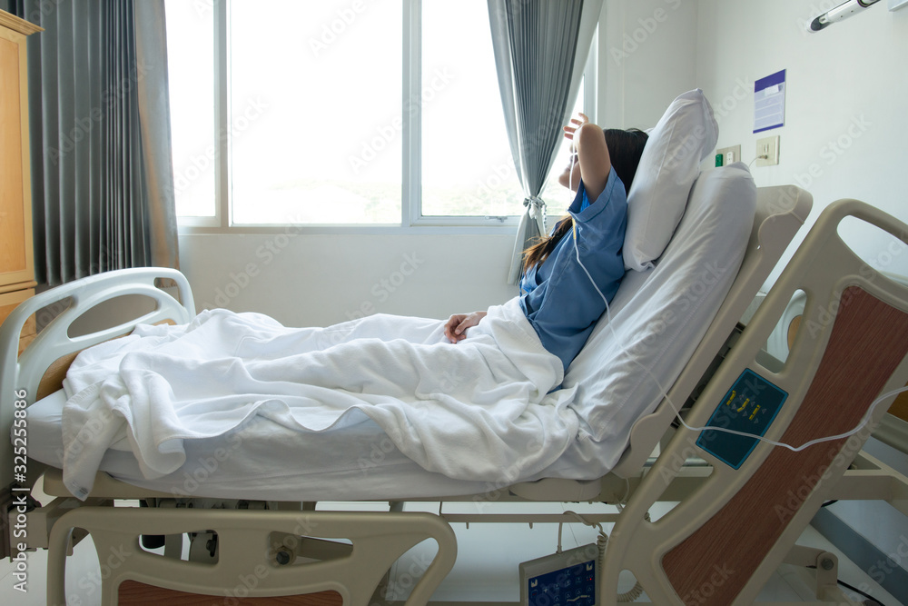 Portrait of sickness patient woman lying on hospital bed, feeling sad ...