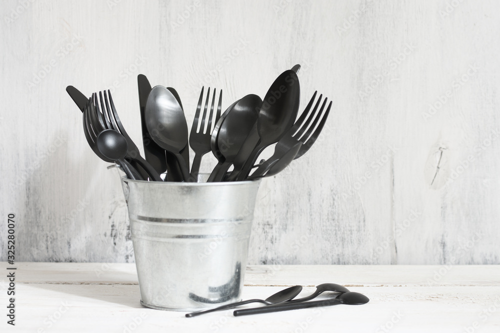 Set of black cutlery in galvanized bucket Stock Photo | Adobe Stock