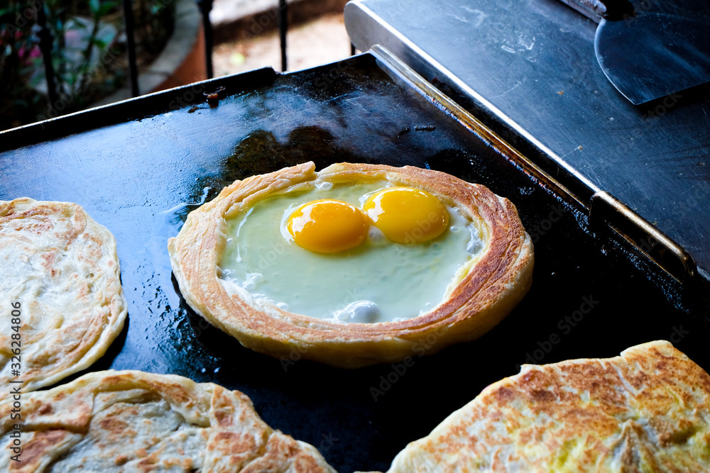 A picture of "roti sarang" in the making at the hot pans. It is pratha ...