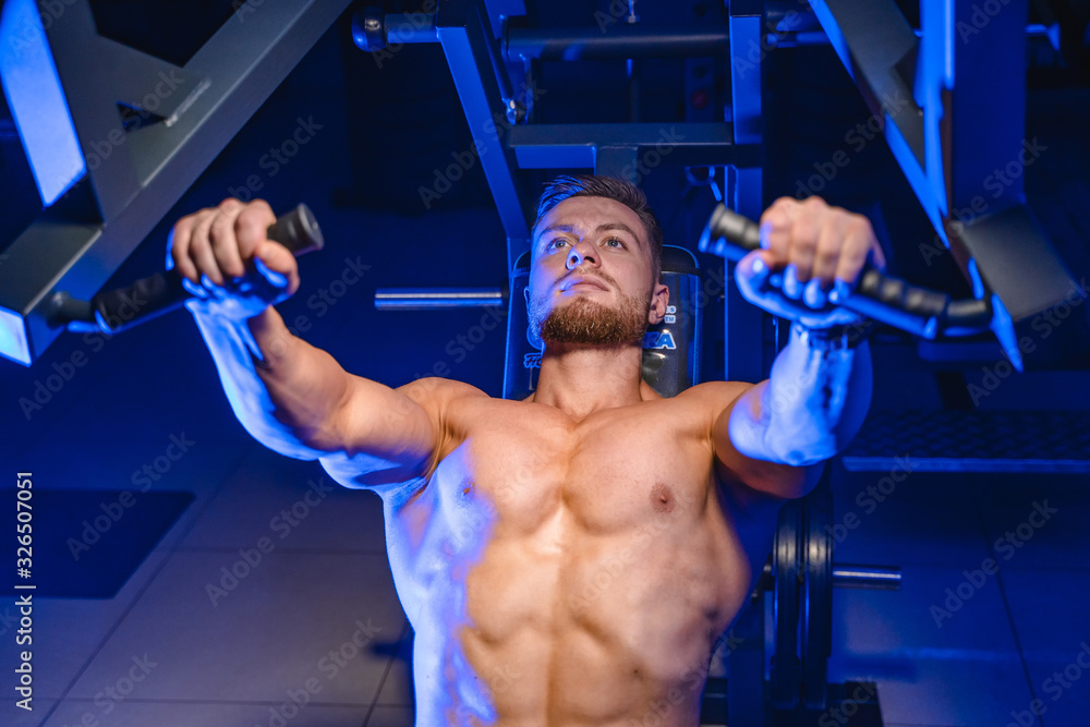 Shirtless young bodybuilder doing bench press for chest. Strong abs ...