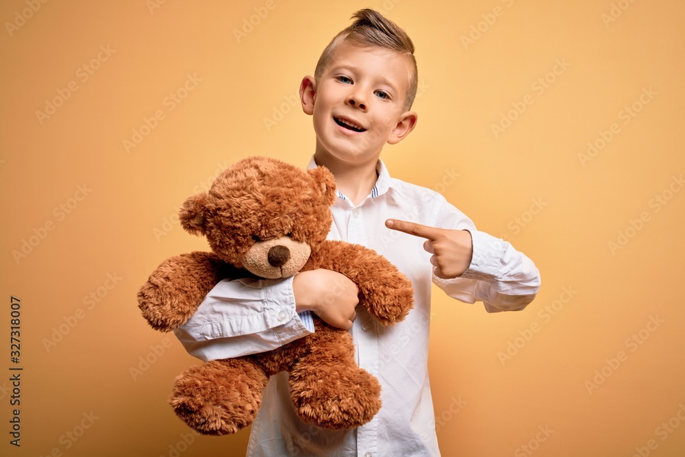 Young little caucasian kid hugging teddy bear stuffed animal over ...