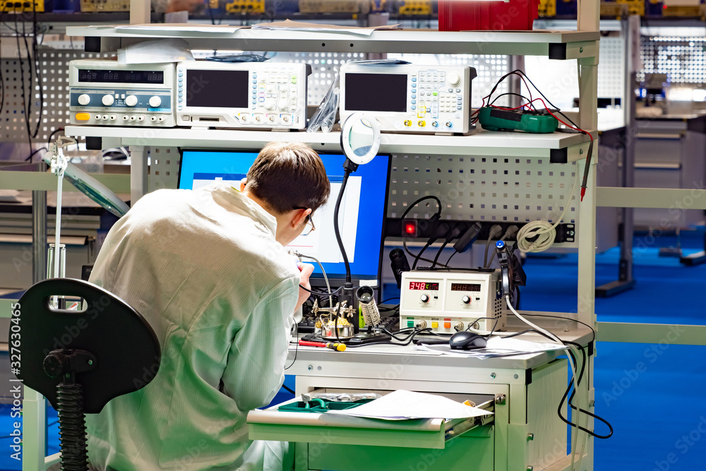 Man in a technology laboratory. Man with a soldering iron at the desk ...