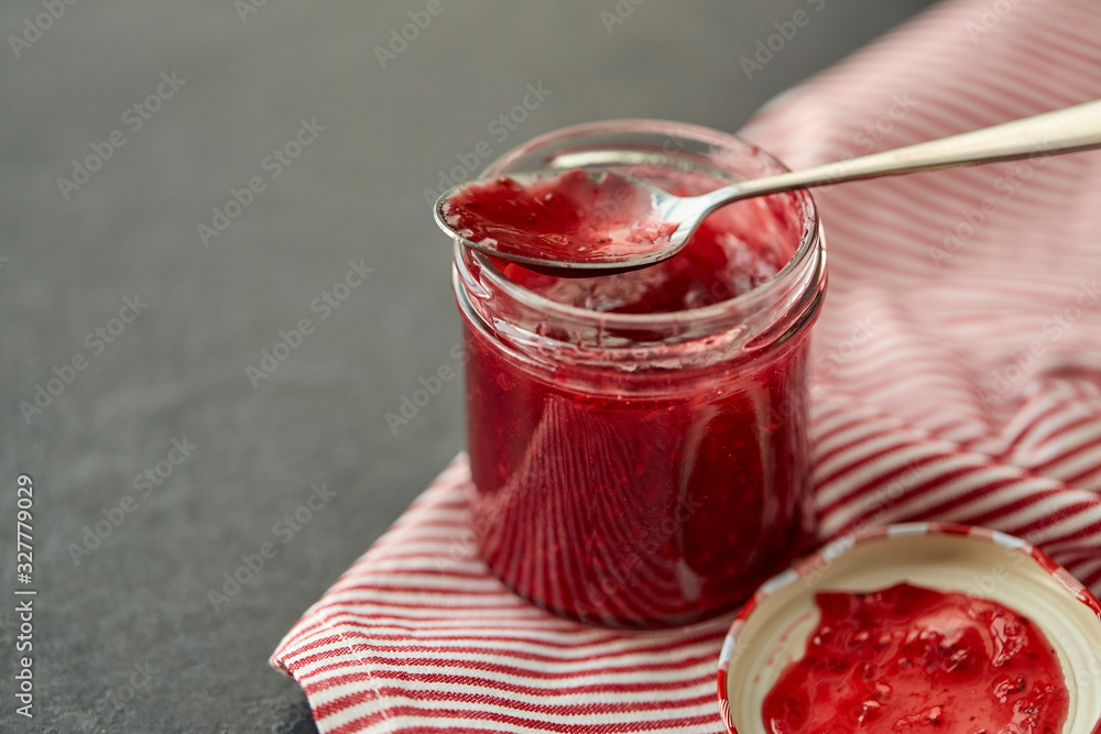 food, preserves and eating concept - mason jar with red raspberry jam ...