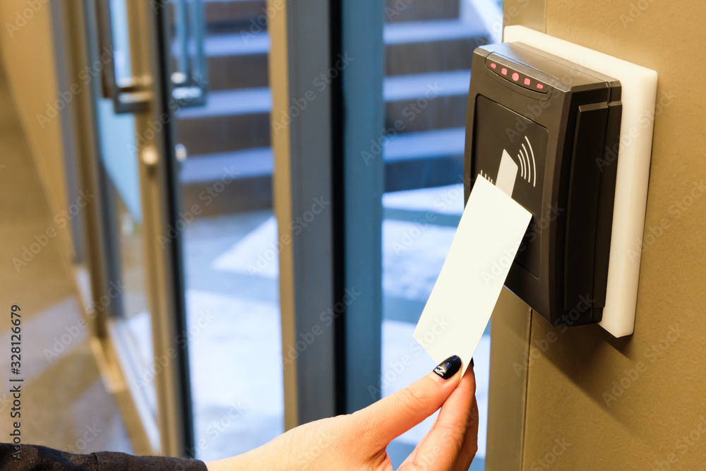 Women hand reaching to use RFID key card to access to office building ...