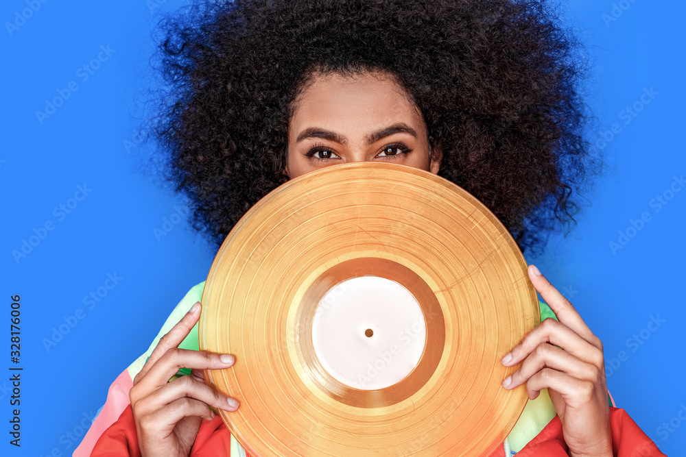 Freestyle. girl standing isolated on blue covering face with phonograph ...