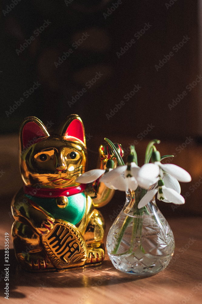 Snowdrops in a crystal vase next to a cat figure Stock Photo | Adobe Stock