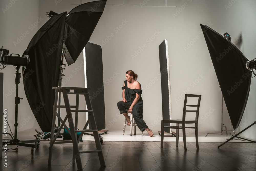Beautiful and attractive model in black dress. Backstage shooting ...