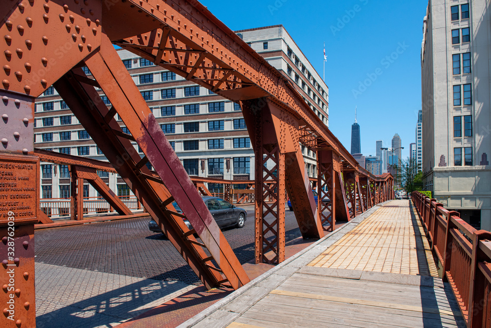 On the West Chicago Avenue bridge sidewalk, facing the city skyscrapers ...