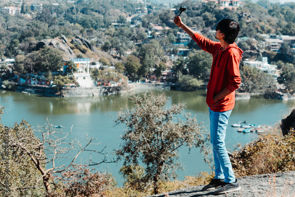 Foto de Stock Indian man using action camera in front of the Nakki Lake ...