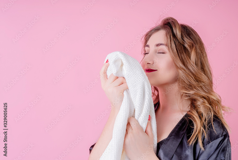 beautiful woman smelling clean clothes isolated on pink background ...