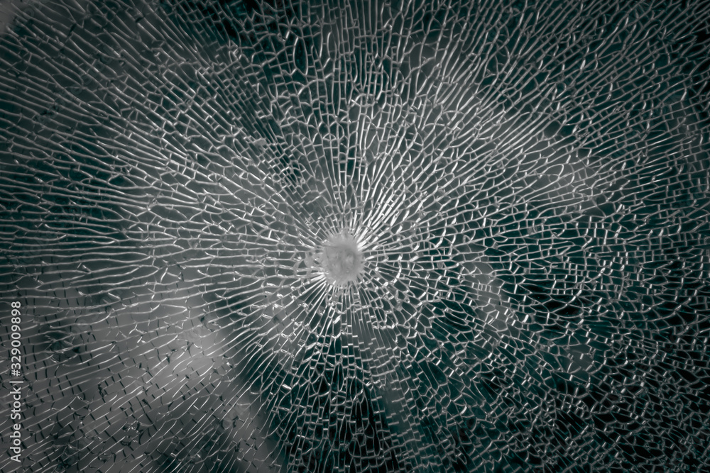 Cracks in the glass on the black background or Bullet hole. Isolated ...