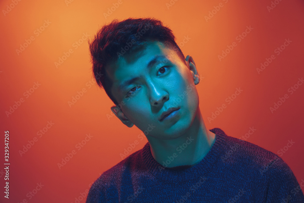 Portrait of a guy with colorful neon light on gradient studio ...