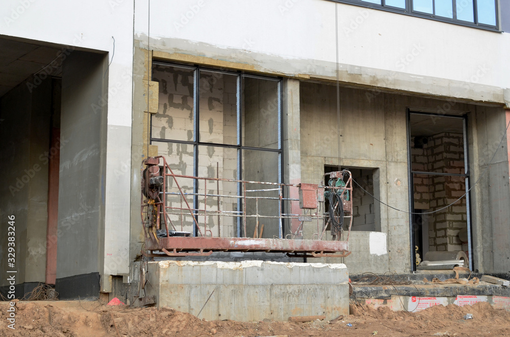 Suspended construction cradle on the background facade of the building ...