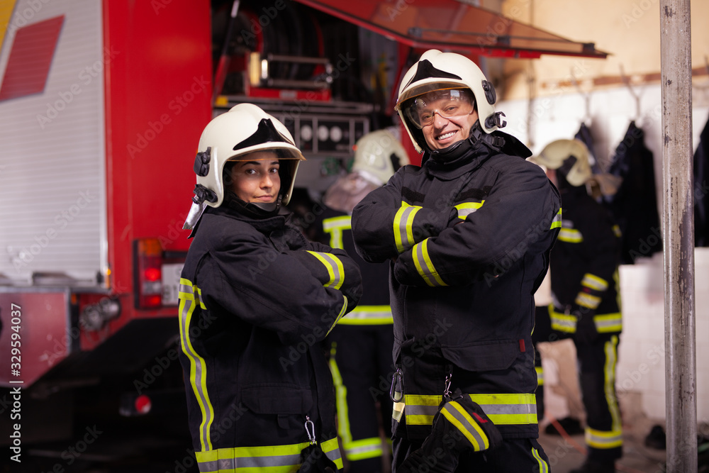 Two professional firefighters with uniforms and protective helmets ...