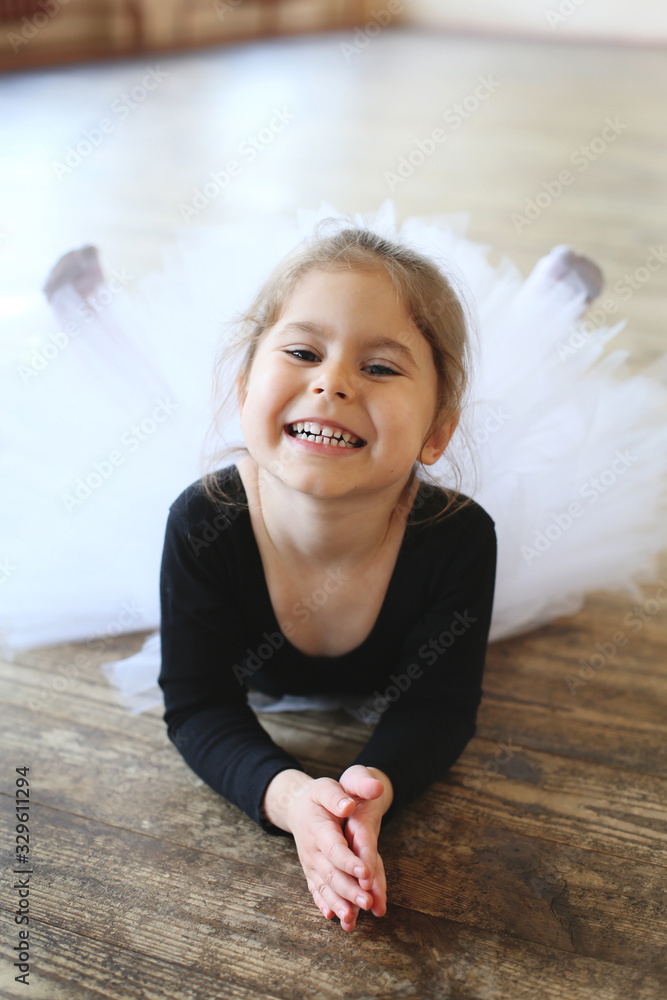Foto de Stock vertical photo of a laughing little ballerina lying on ...