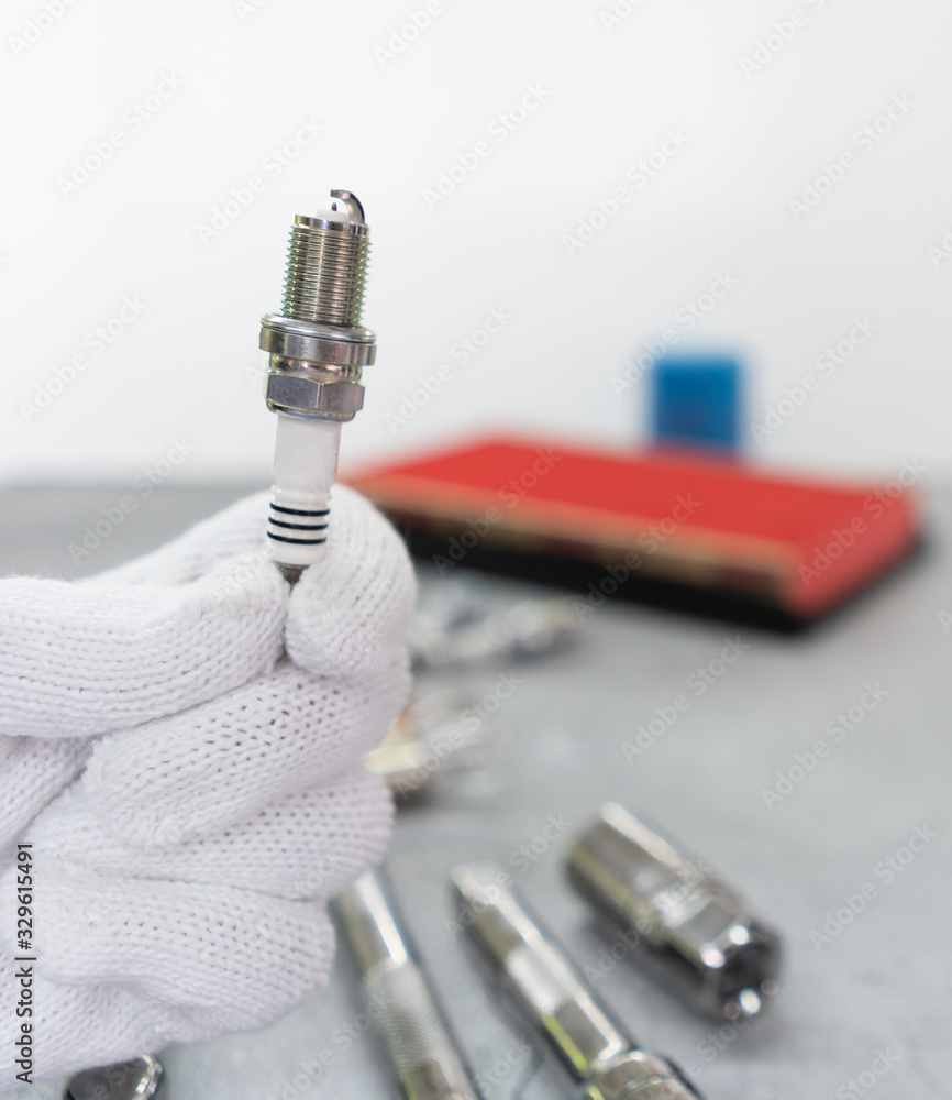 Mechanic hold new spark plug small electrode for good and high ...