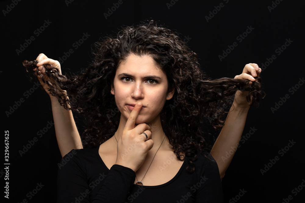 Attractive caucasian curly girl with stern look in her face holding ...