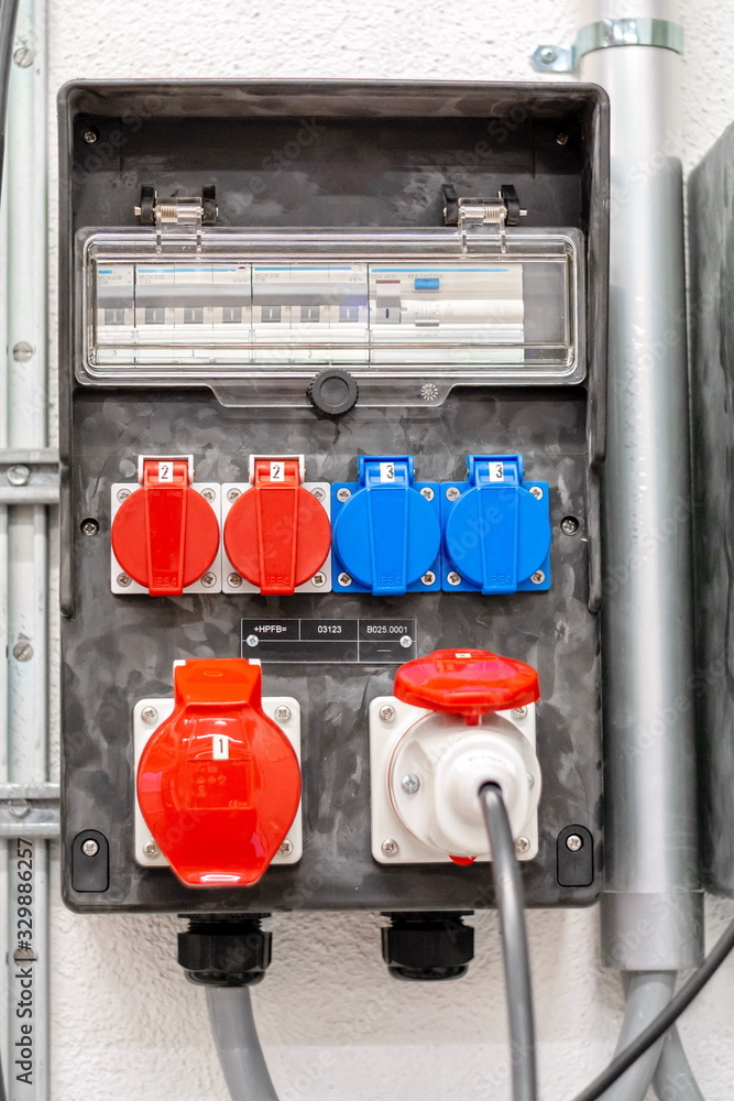 Wall mounted electrical panel with colored outlets sockets and cables ...