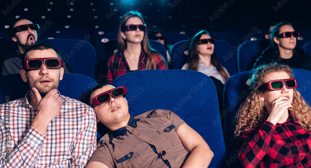 Spectators in a movie theater are sitting and watching a movie in 3D ...