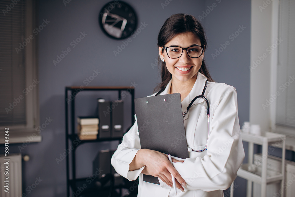 Portrait of young female medical professional posing amidst her ...
