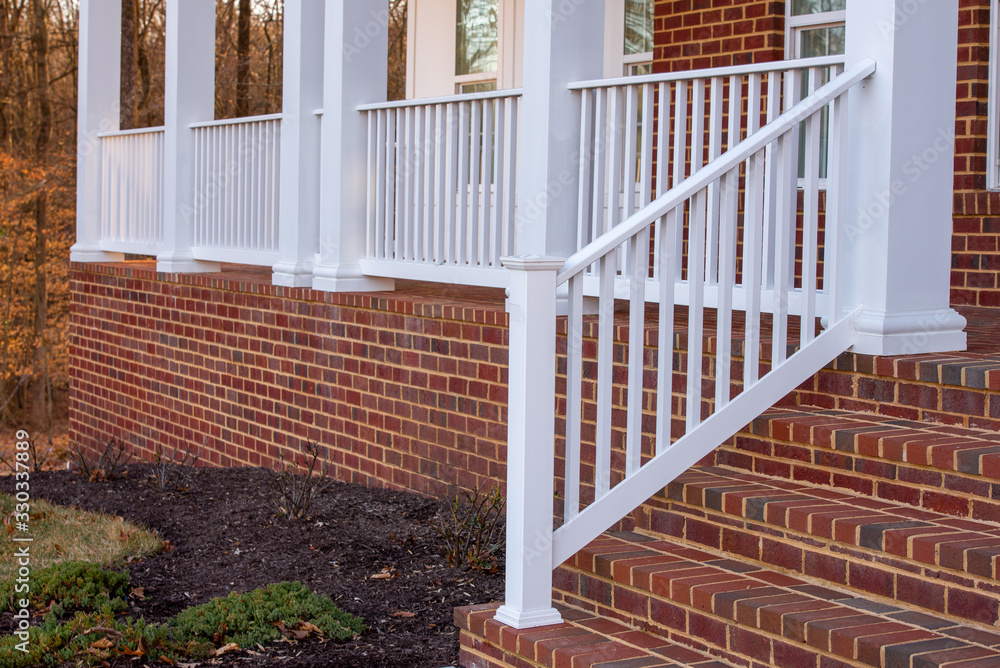 Covered porch with brick siding, pre cut and pre mitered white columns ...