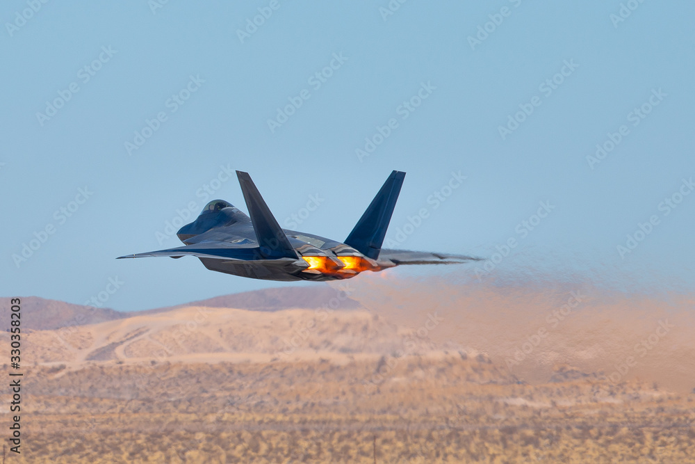 Very low pass of a F-22 Raptor against the Nevada hills, with ...