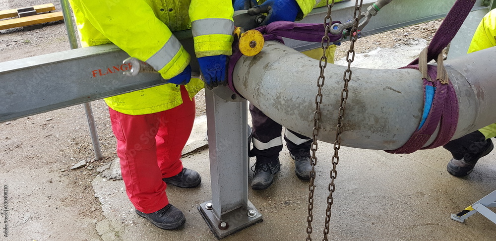 riggers move the pipe using two chain blocks Stock Photo | Adobe Stock