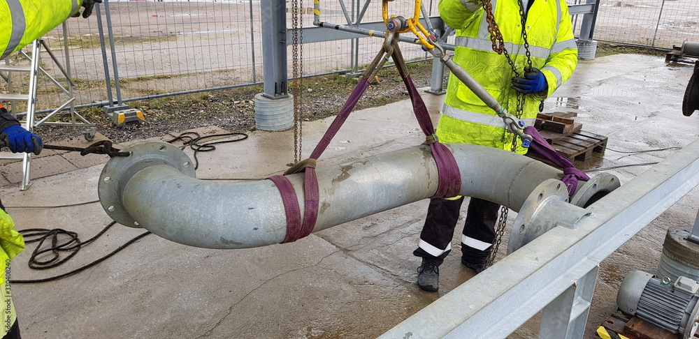 riggers move the pipe using two chain blocks Stock Photo | Adobe Stock