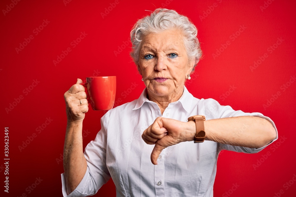 Senior beautiful woman drinking mug of coffee standing over isolated ...