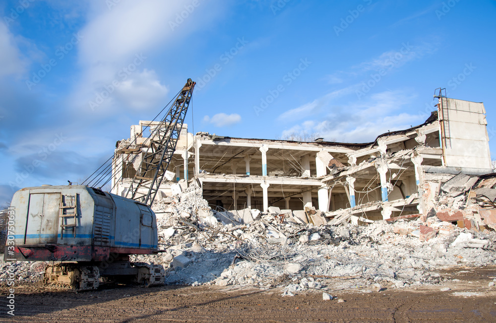 Crawler crane with a heavy metal wrecking ball on a steel cable at ...