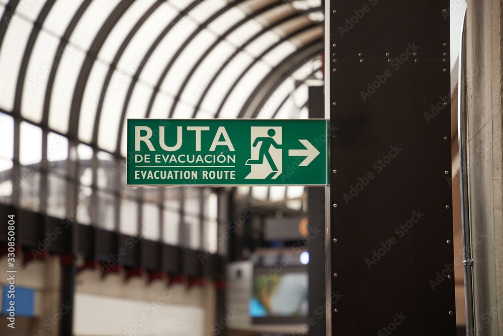 Emergency exit evacuation route sign in Spanish language at an airport ...