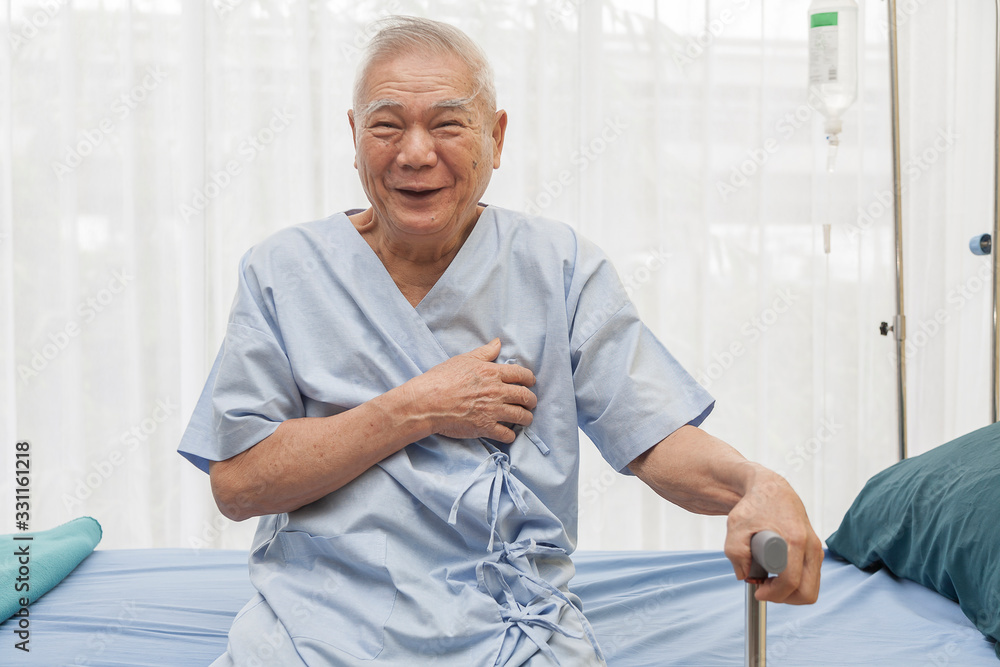 Photo Stock Elderly positive happy Asian man or Patient seated on bed ...