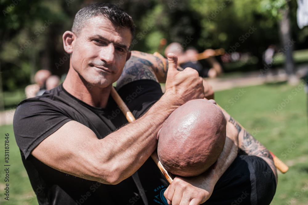 Filipino escrima instructor and student practice stick fight choke ...